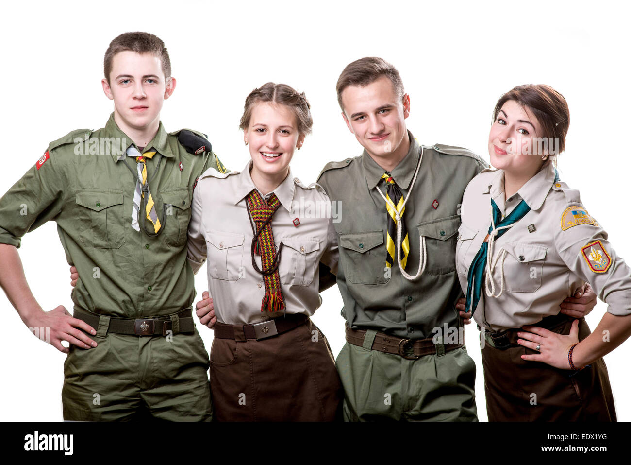 Four young scout members embracing in uniform isolated on white ...