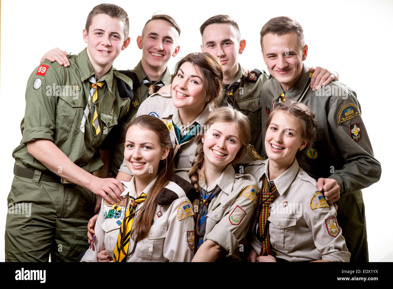 Friendly young scouts in uniform embracing together isolated on white ...