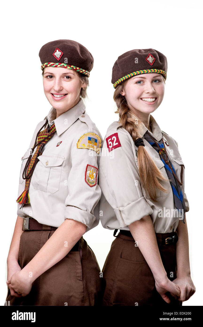 Two young scout girls standing together in hat and uniform isolated on ...
