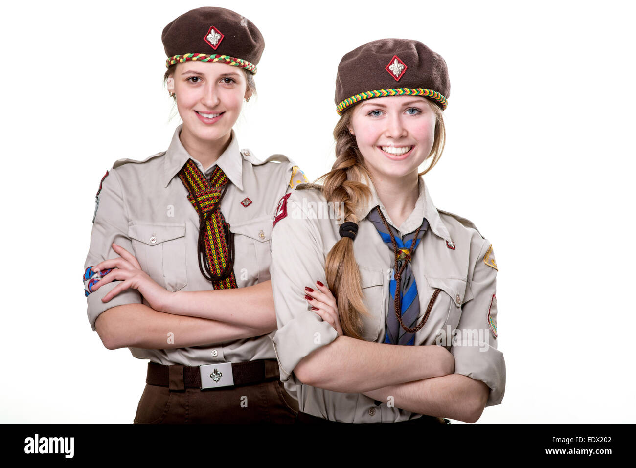 Two young scout girls standing together in hat and uniform isolated on ...