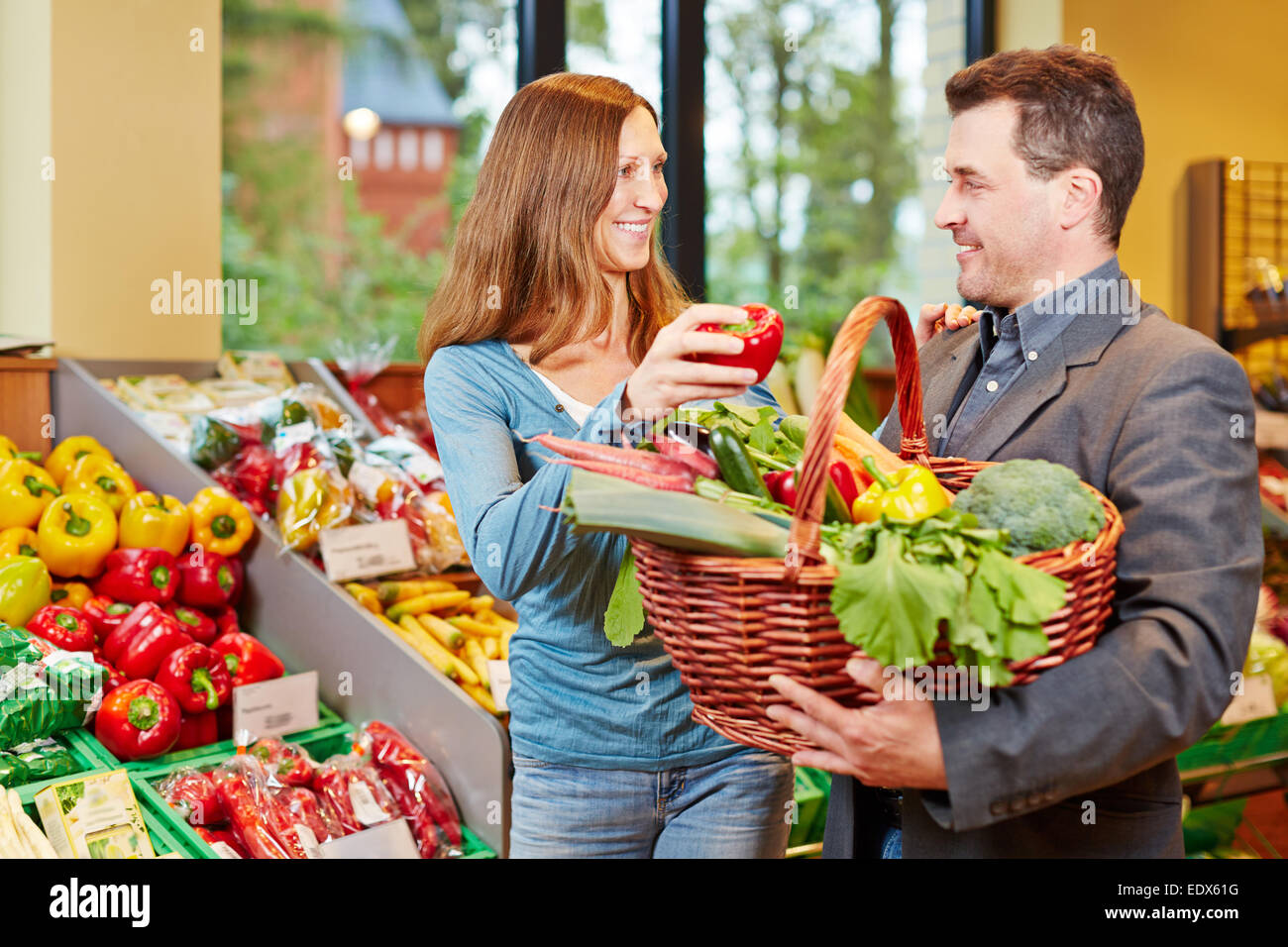 Happy couple in supermarket buying fresh vegetables together Stock ...