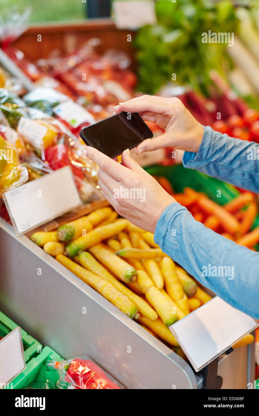 App in smartphone scanning barcode for price comparison in supermarket ...