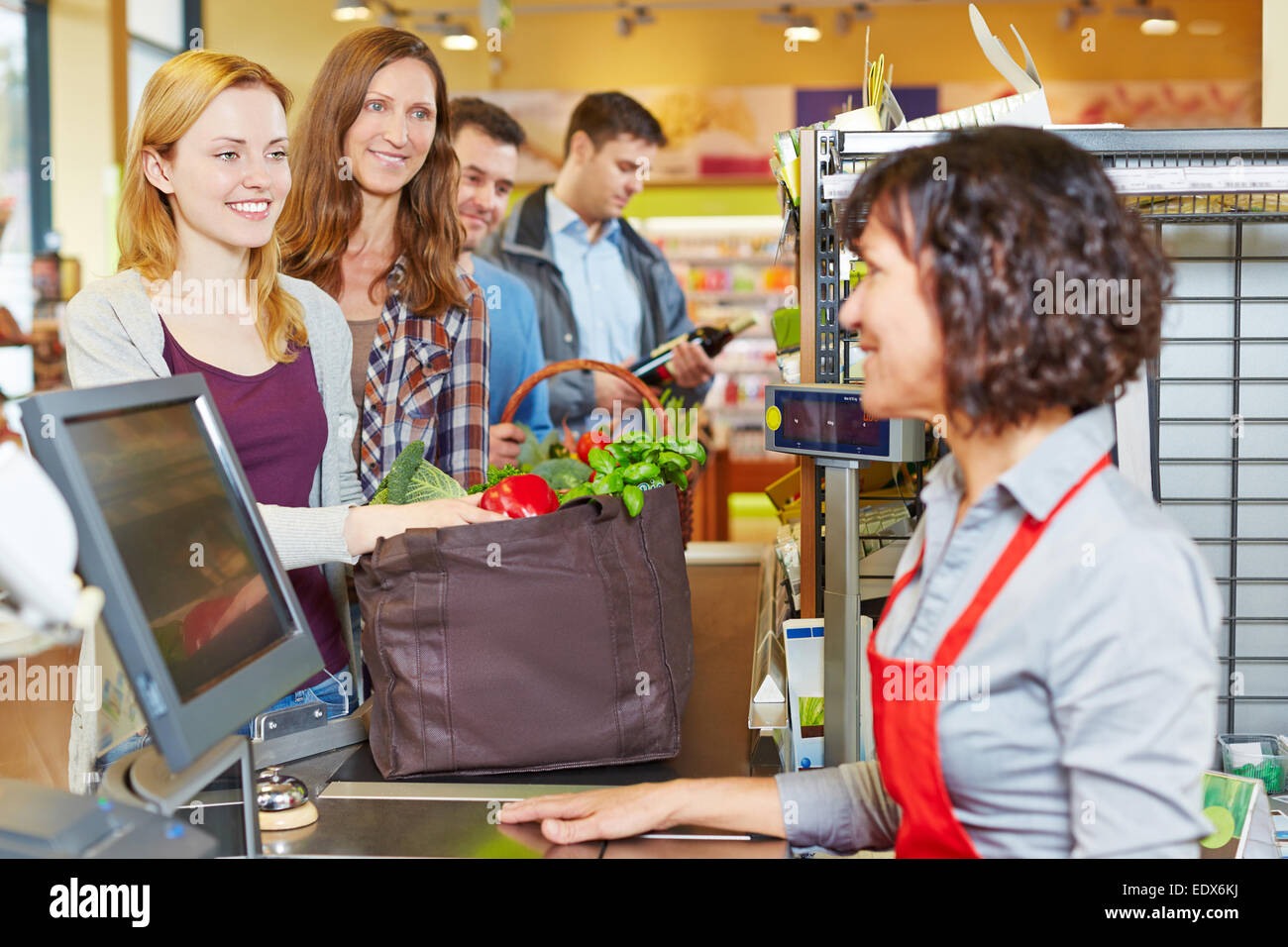 Woman with groceries waiting in line at the supermarket checkout Stock ...
