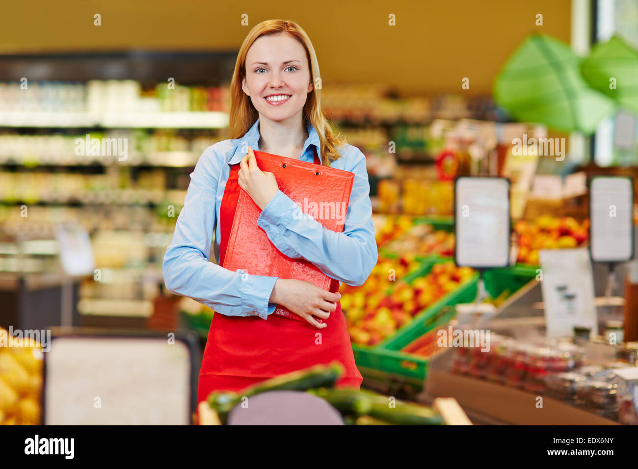 Smiling young saleswoman standing in supermarket with a checklist Stock ...