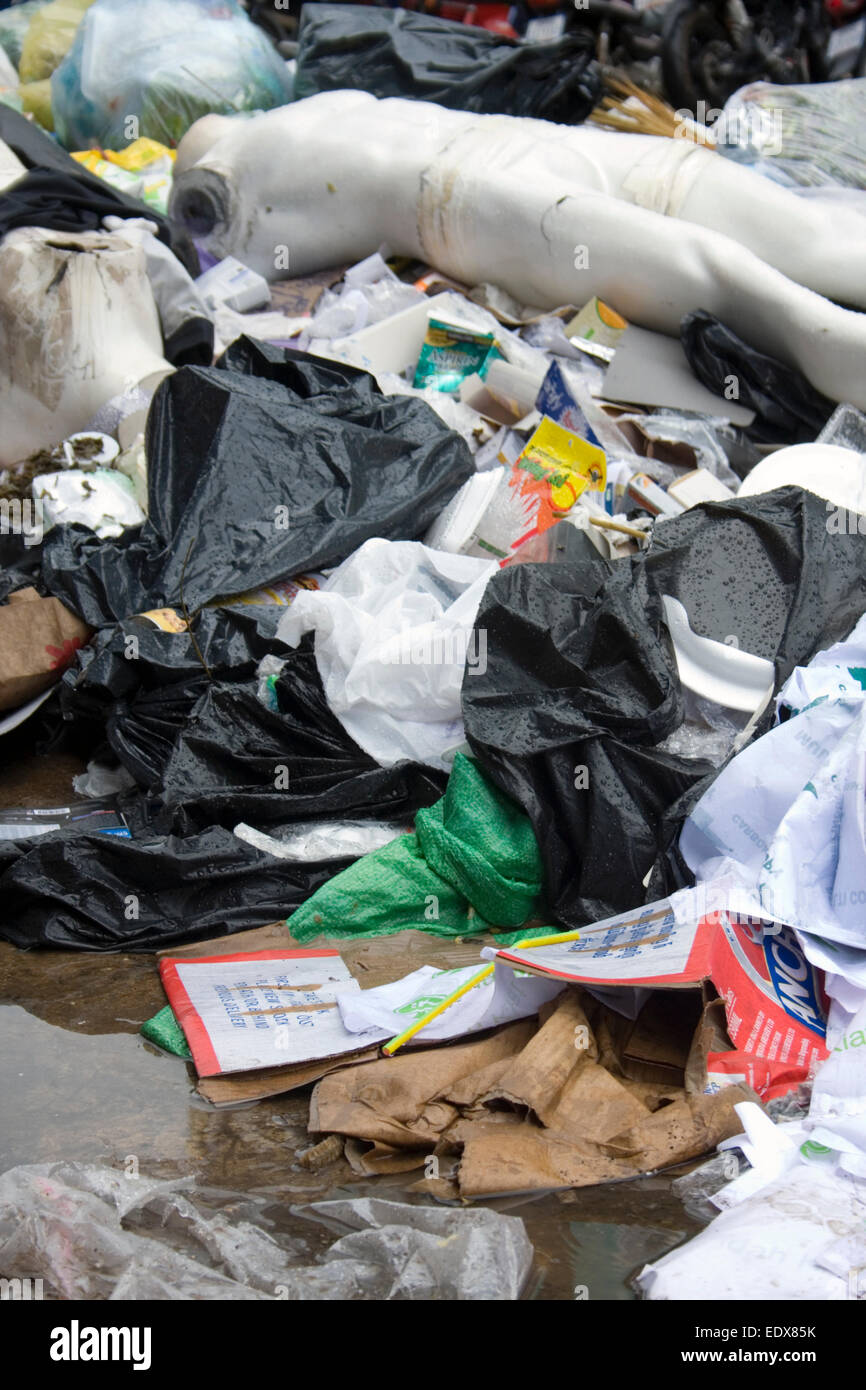 A mannequin rests in a large pile of garbage on a city street in Phnom ...