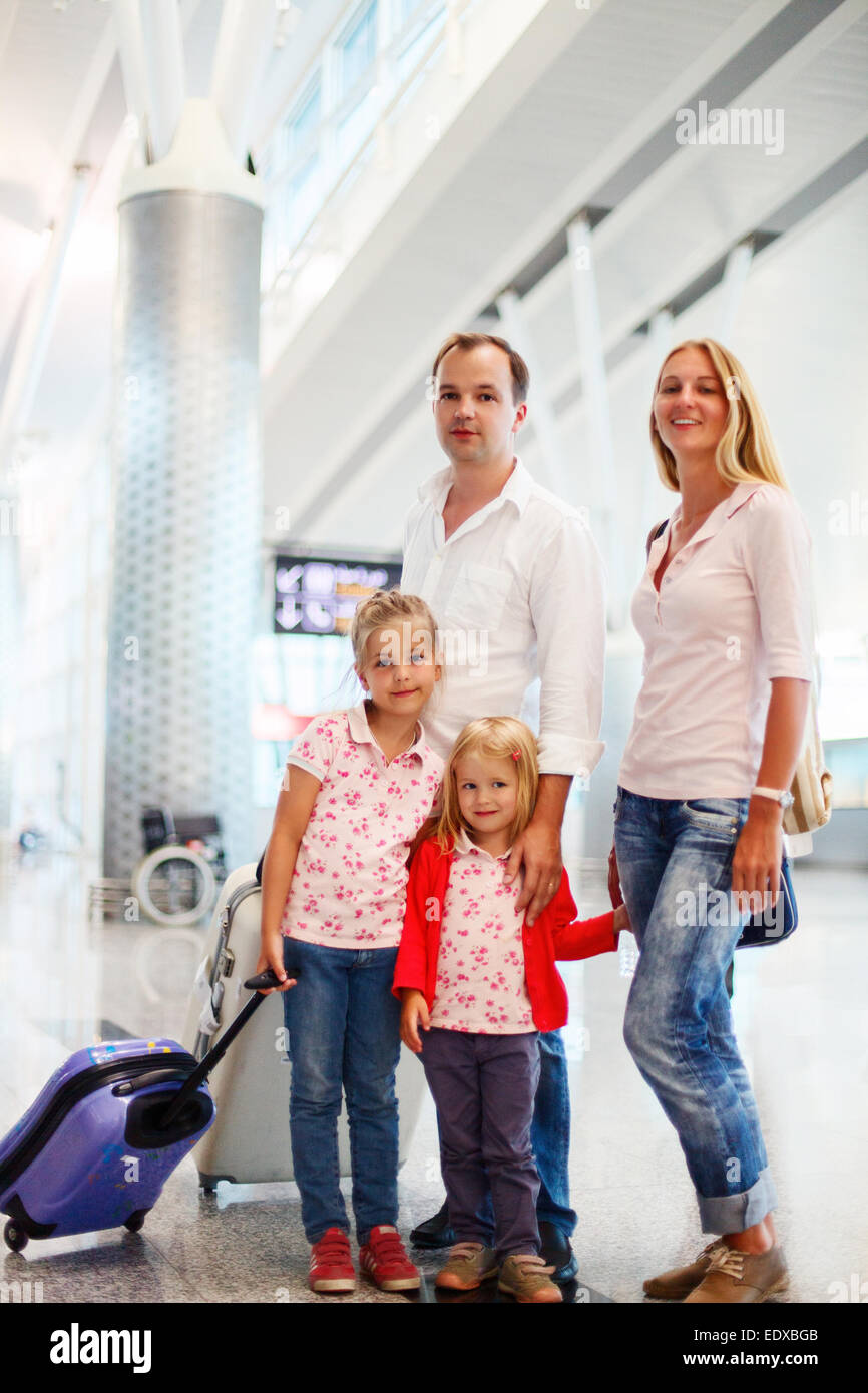 Portrait of traveling family of four with suitcases in airport Stock ...