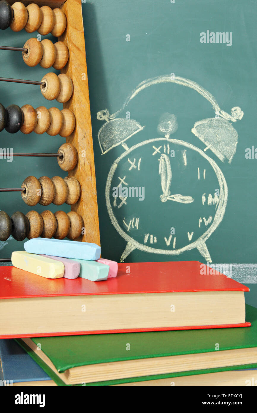 Education concept. Books, abacus, chalk and chalk drawing of alarm ...