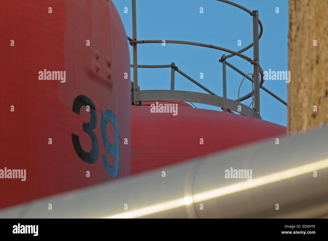 Red tanks with railing against blue sky Stock Photo - Alamy
