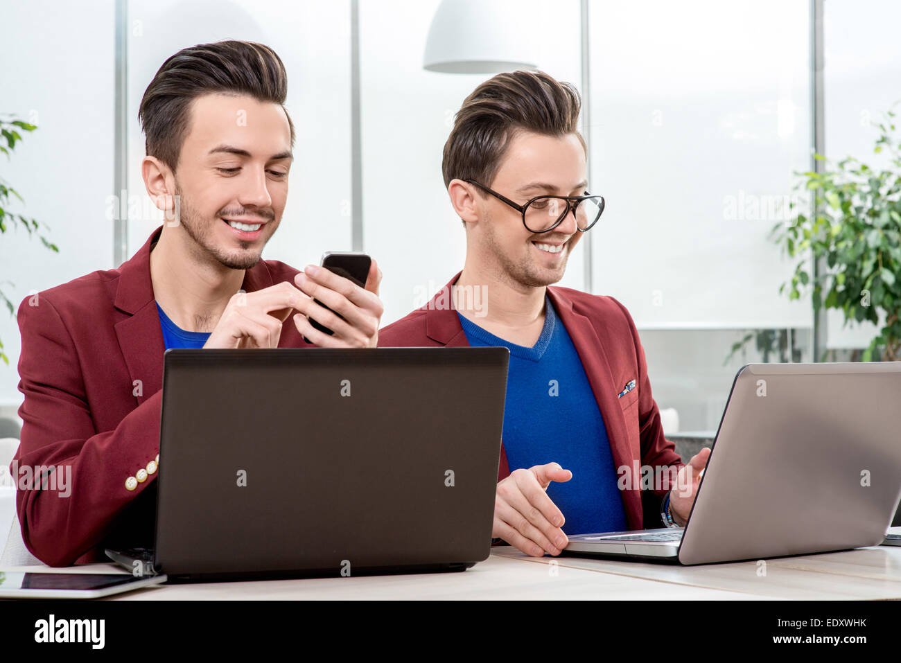 Two brothers twins working at the office Stock Photo - Alamy