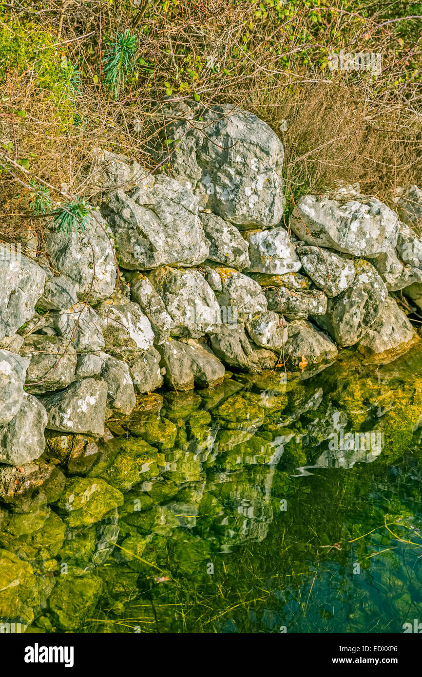 Ancient water trough with surrounding nature reflecting in the water at ...