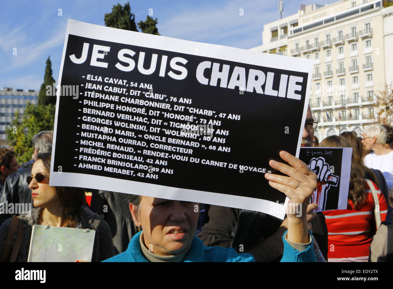 A woman holds up a 'Je suis Charlie' sign with the names of all 12 ...