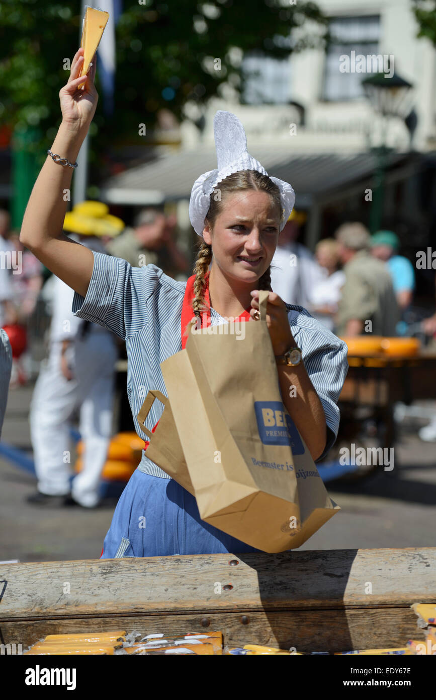 Girl in traditional Dutch costume selling cheese at the cheese market ...