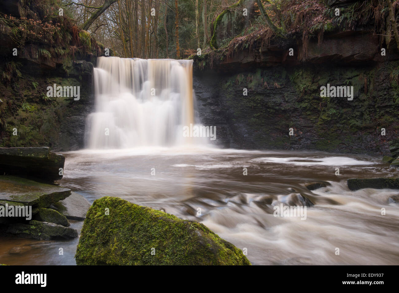 Water from stream flows over scenic Goit Stock Waterfall, surrounded by ...