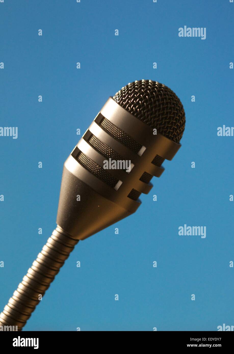 Close up of microphone against a plain blue background Stock Photo - Alamy