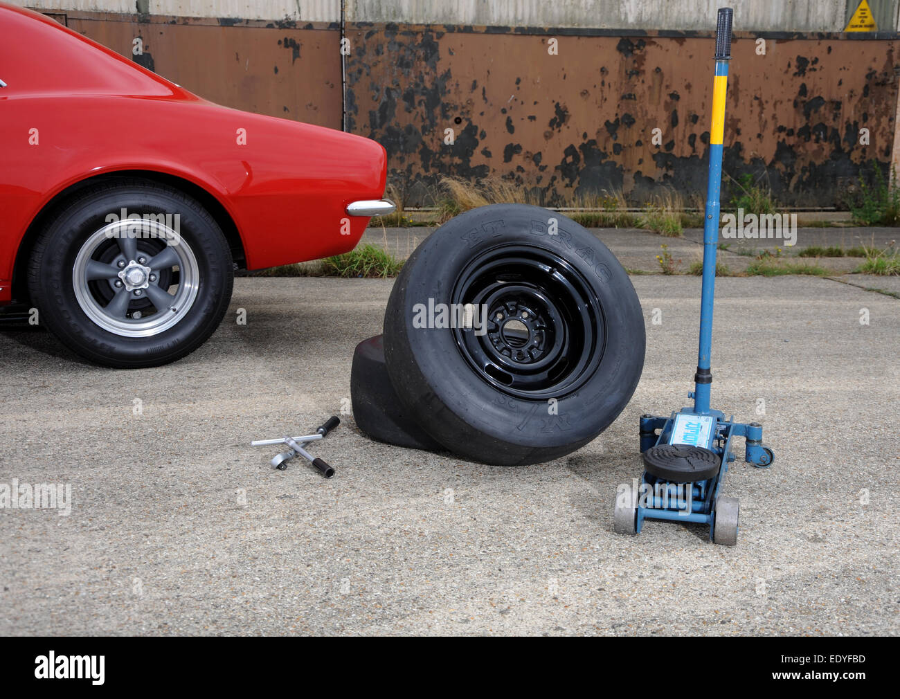 Trolley jack and racing slick tyres ready to change the back wheels and ...