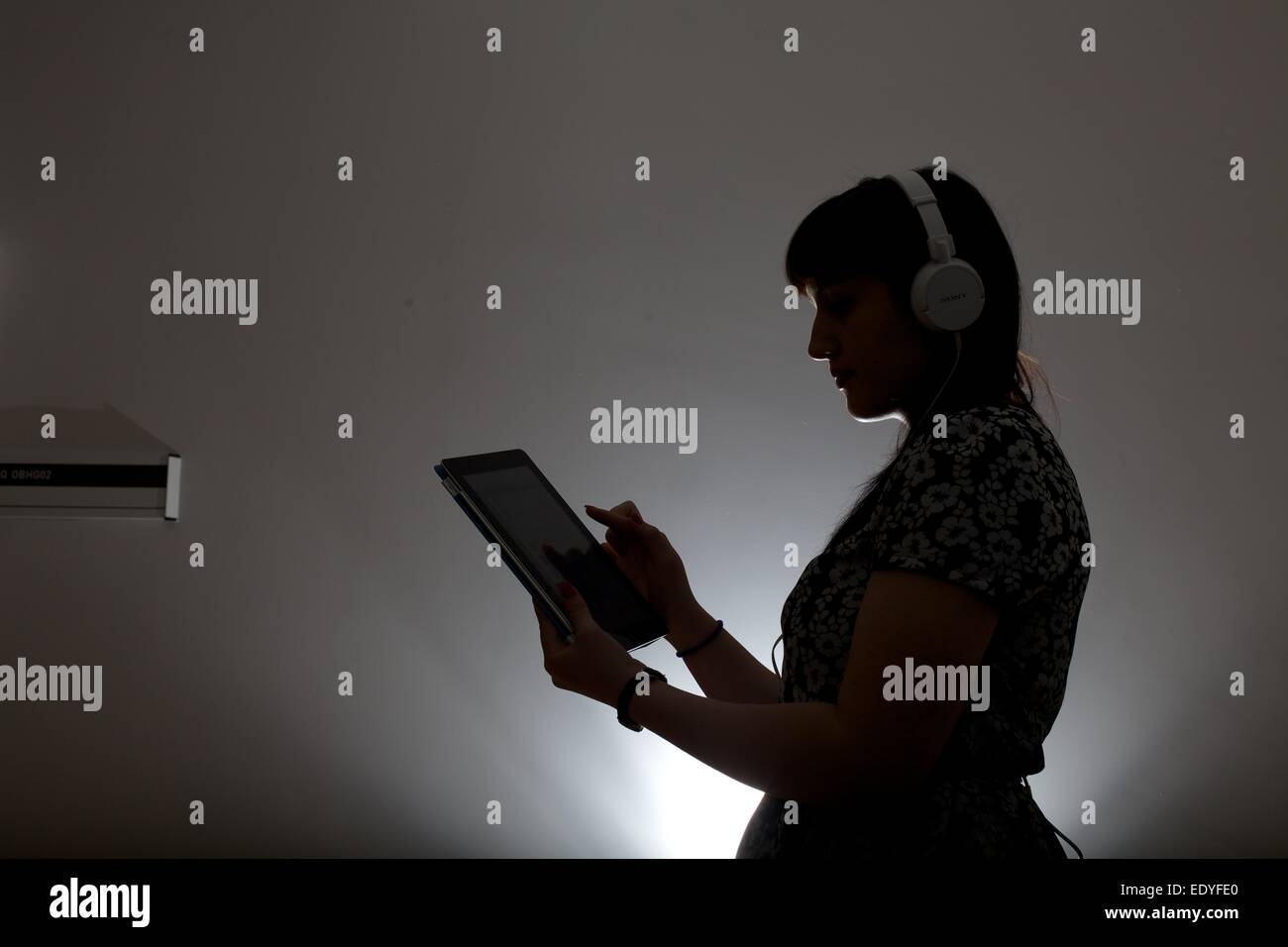 silhouette shot of girl on ipad with headphones Stock Photo - Alamy