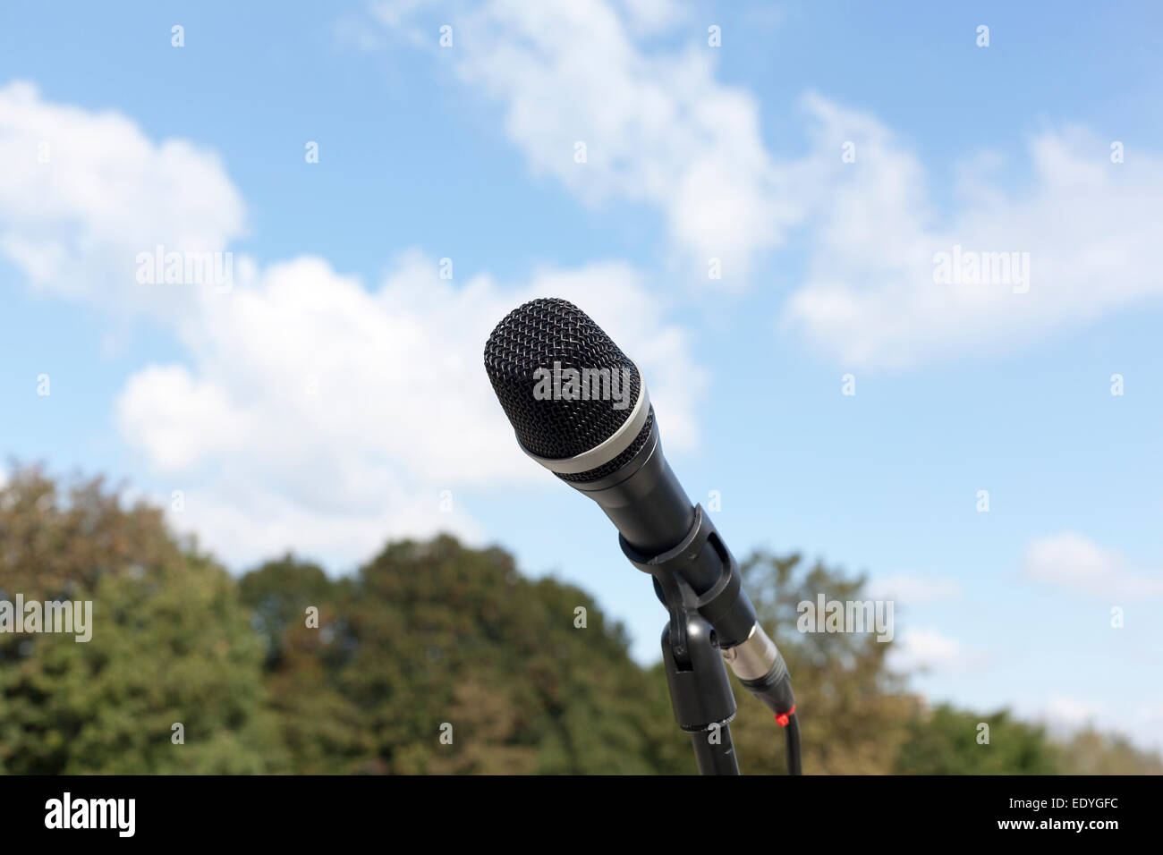 microphone in focus against blurred trees and sky Stock Photo - Alamy