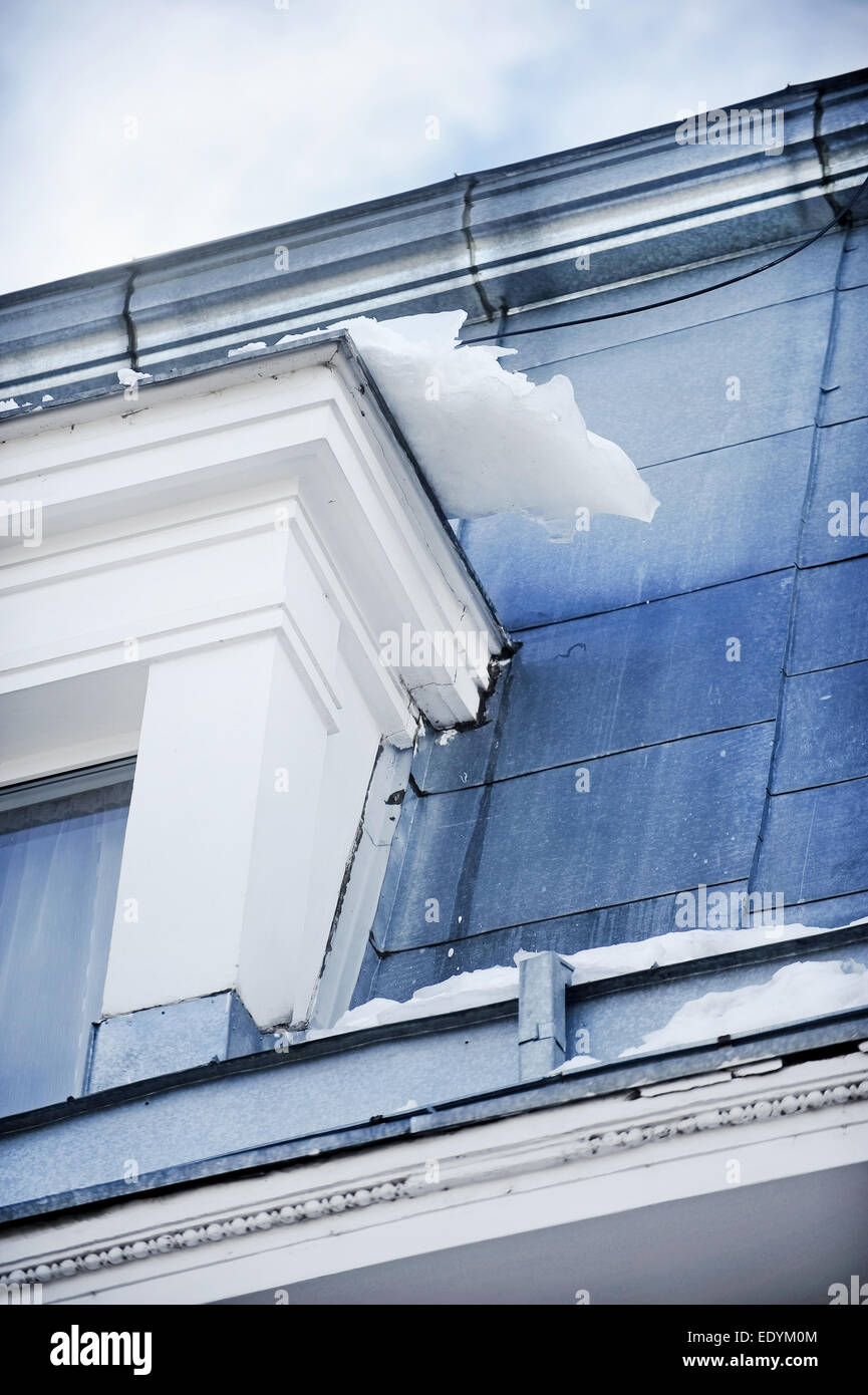 Big piece of ice hanging down from a roof Stock Photo - Alamy
