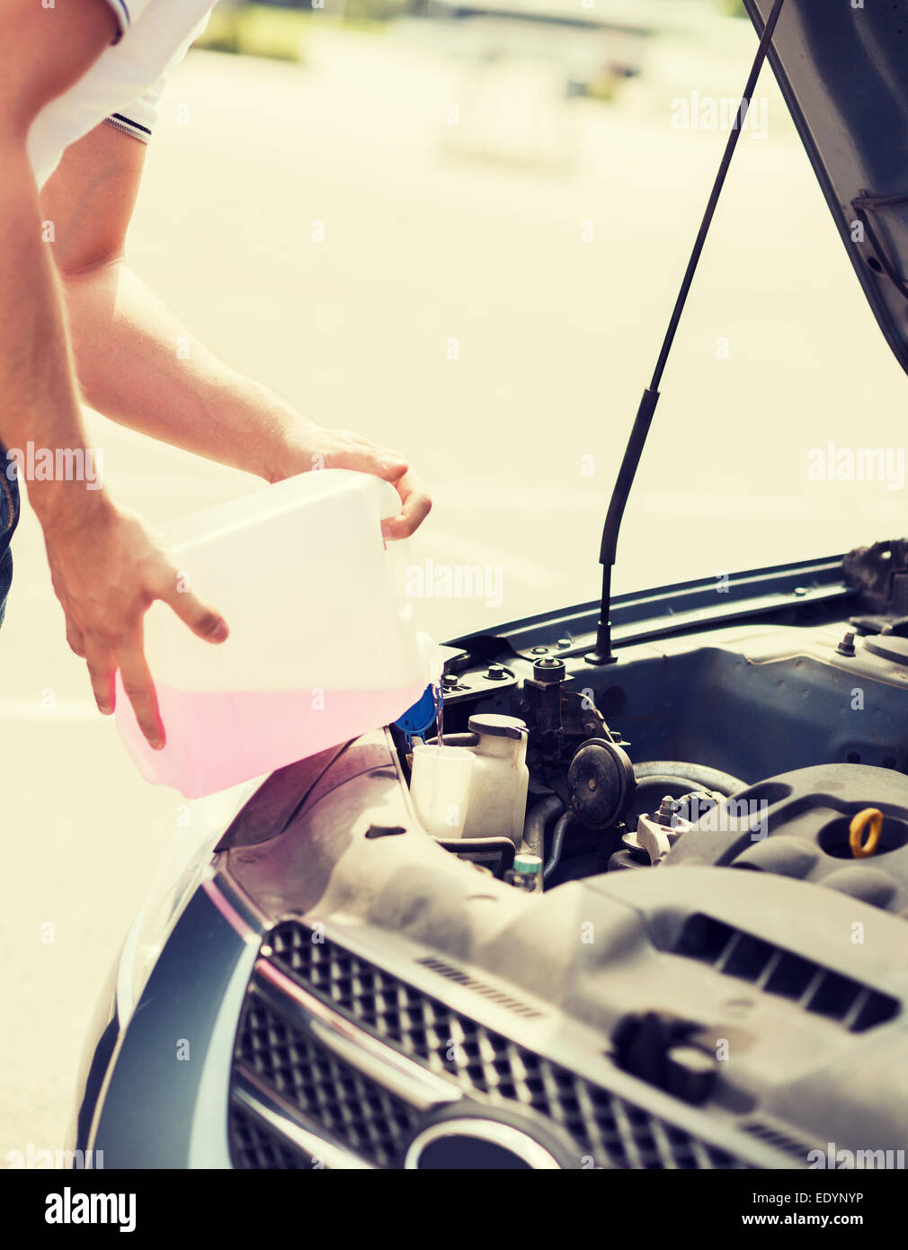 man filling windscreen water tank Stock Photo - Alamy