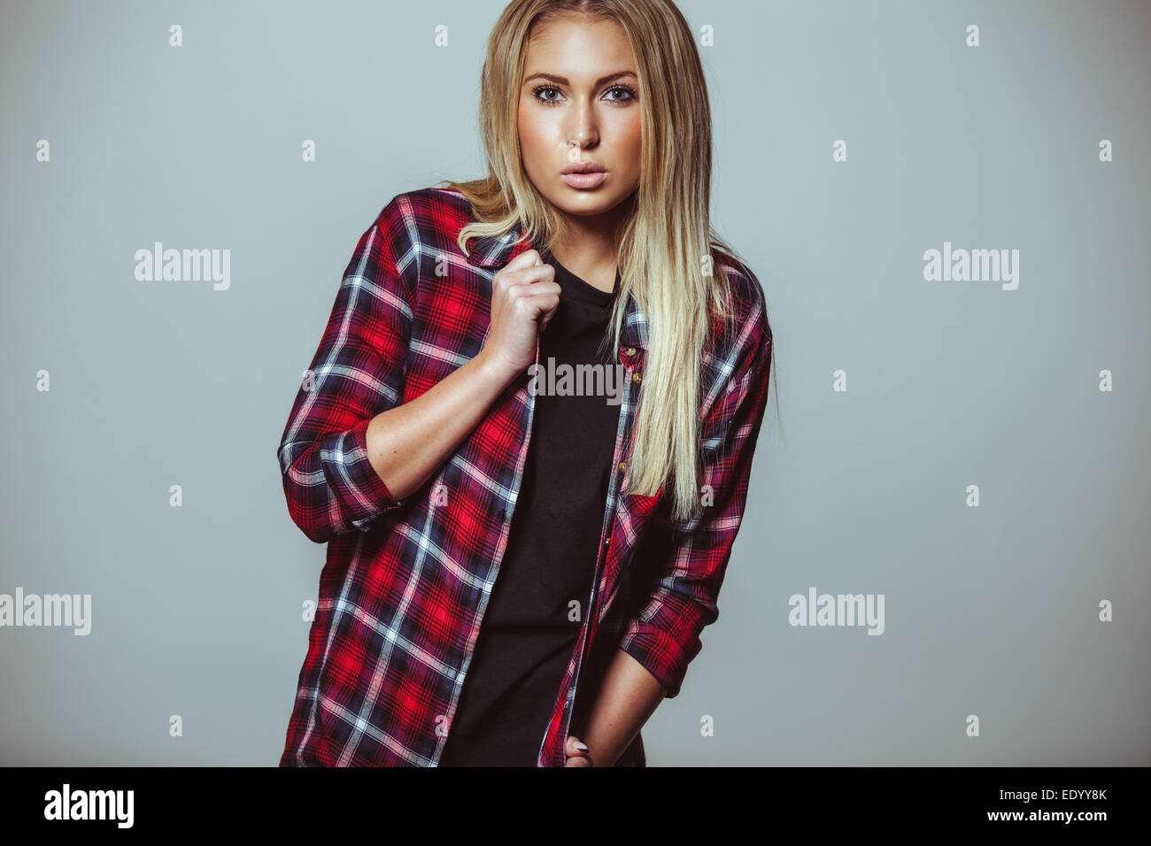 Portrait Of An Attractive Young Woman Standing Against White Wall