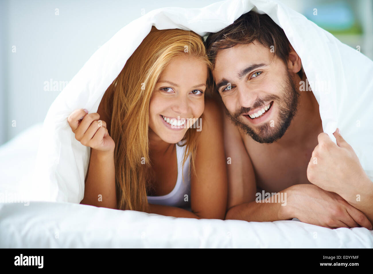 Portrait of young couple under the sheet Stock Photo - Alamy
