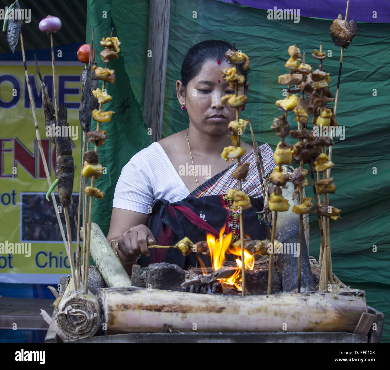 Sivasagar, Assam, India. 12th Jan, 2015. A Mishing tribal woman smokes ...