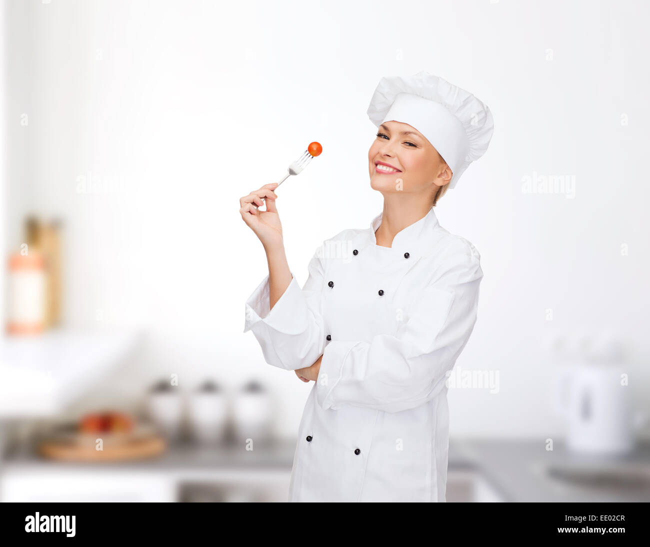 smiling female chef with fork and tomato Stock Photo - Alamy