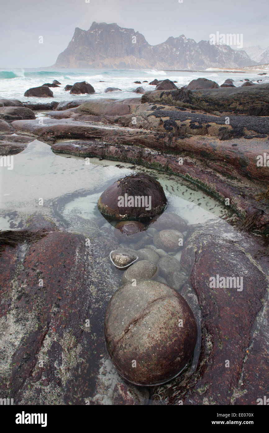 Coastal scene with rock pool and mountains, Utakleiv, Lofoten Islands ...