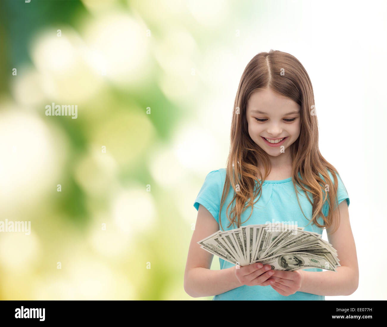 smiling little girl looking at dollar cash money Stock Photo - Alamy
