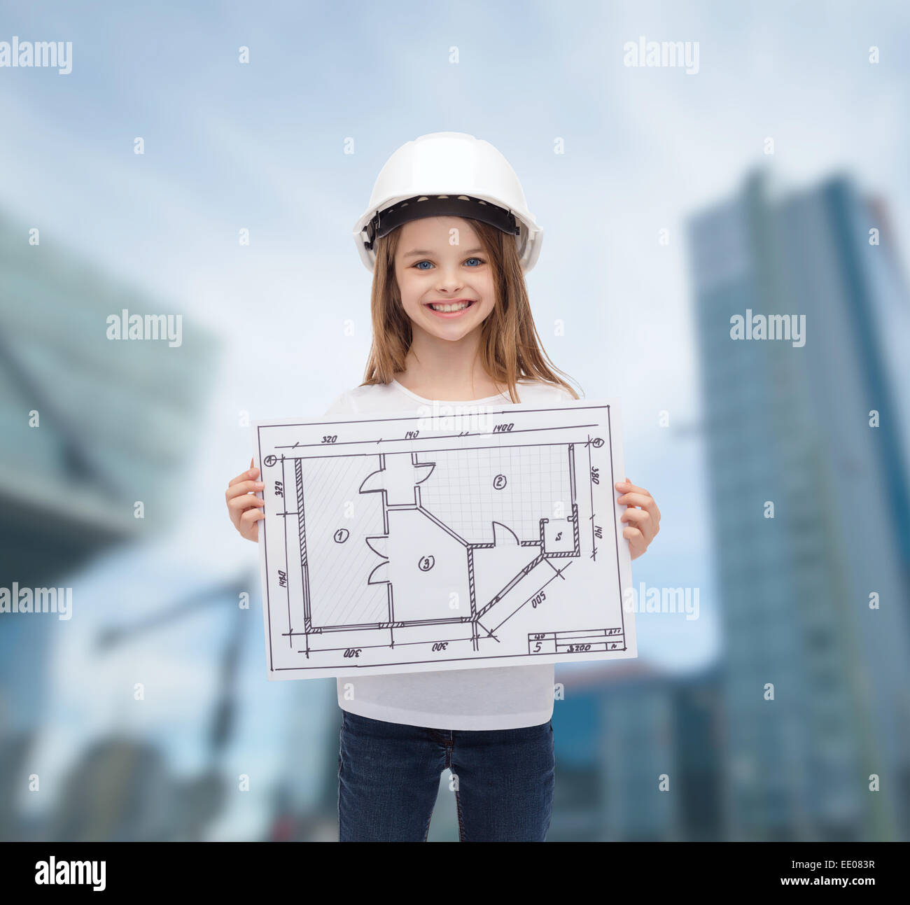 smiling little girl in helmet showing blueprint Stock Photo - Alamy