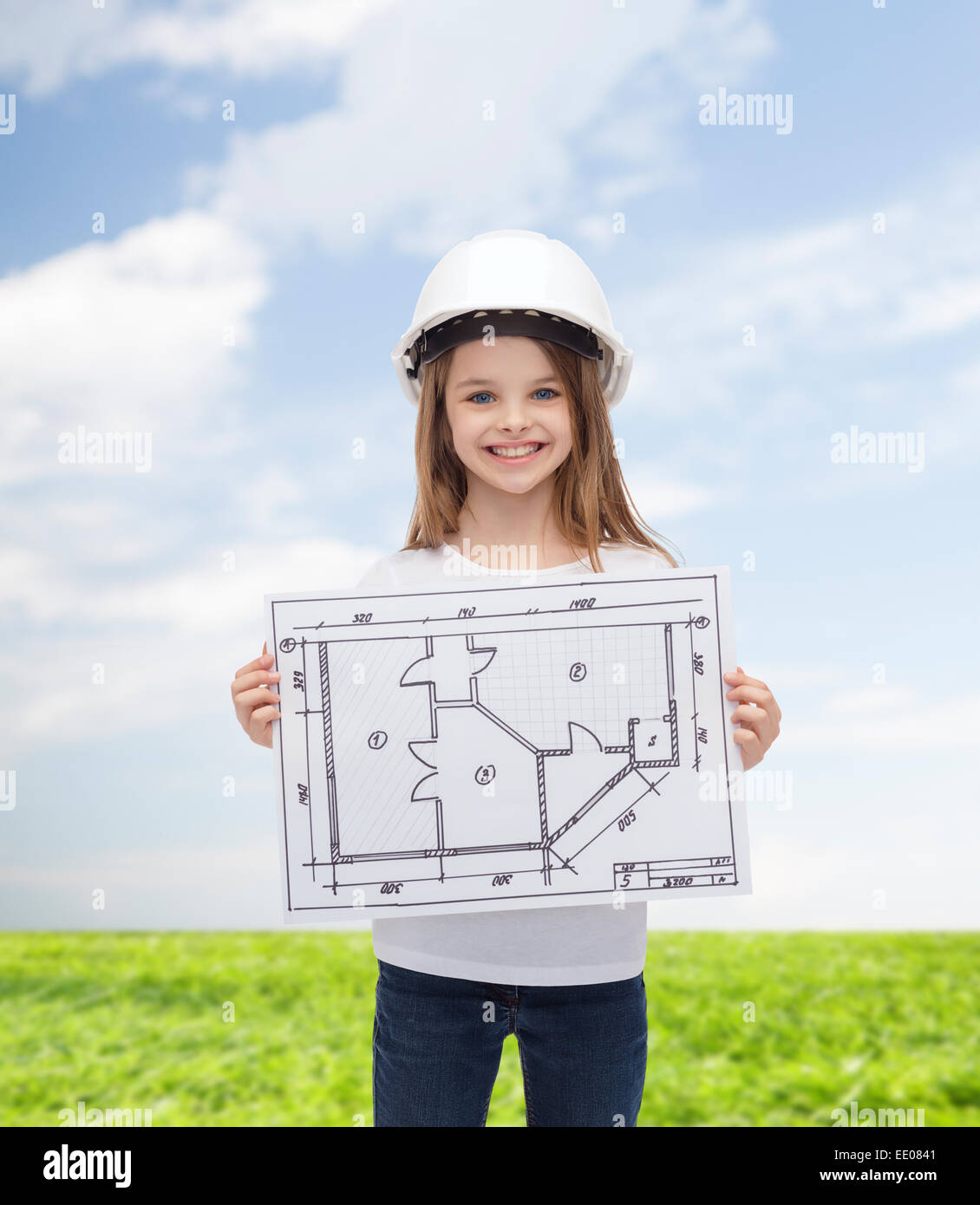 smiling little girl in helmet showing blueprint Stock Photo - Alamy