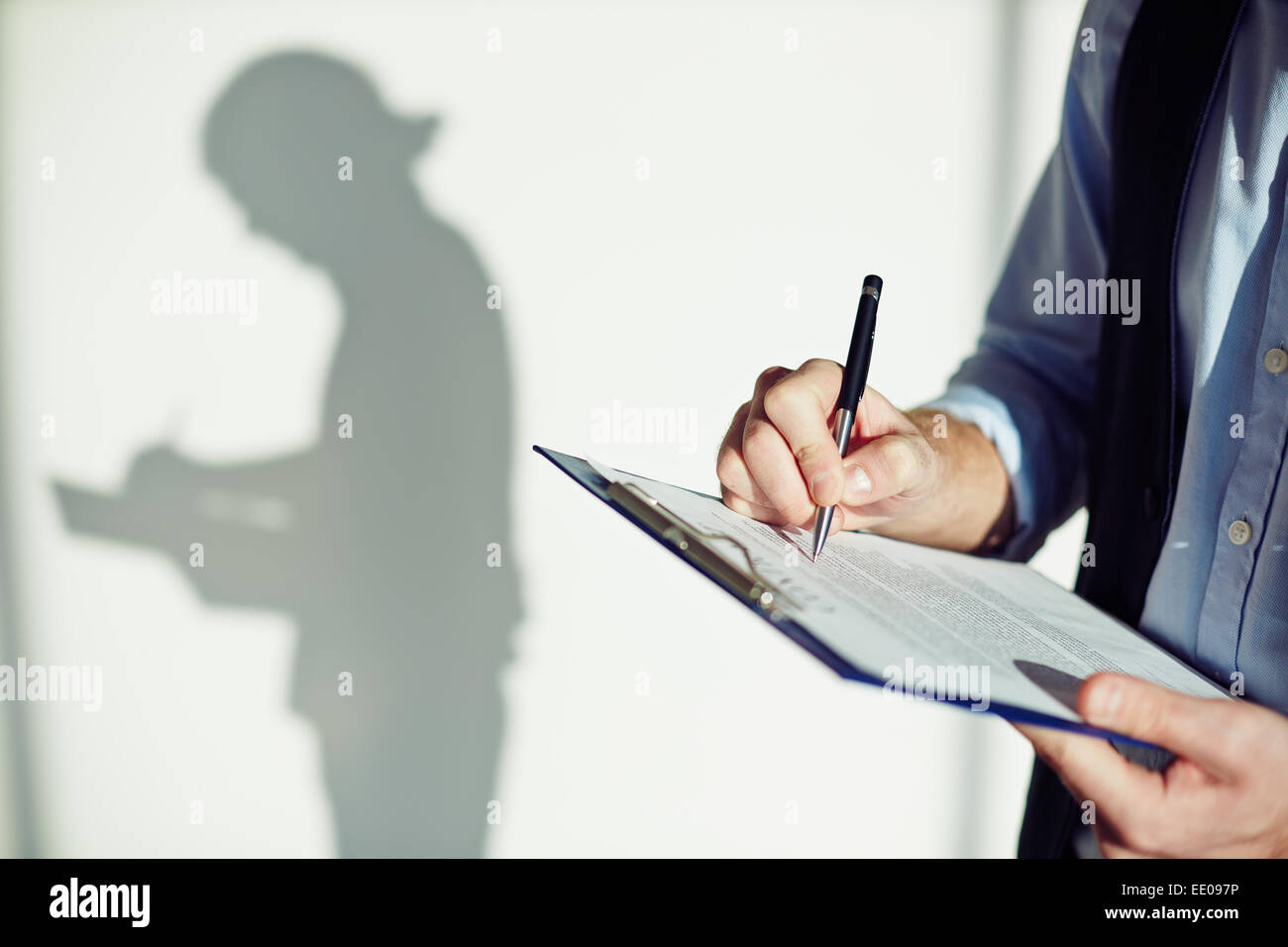 Man filling in document Stock Photo - Alamy