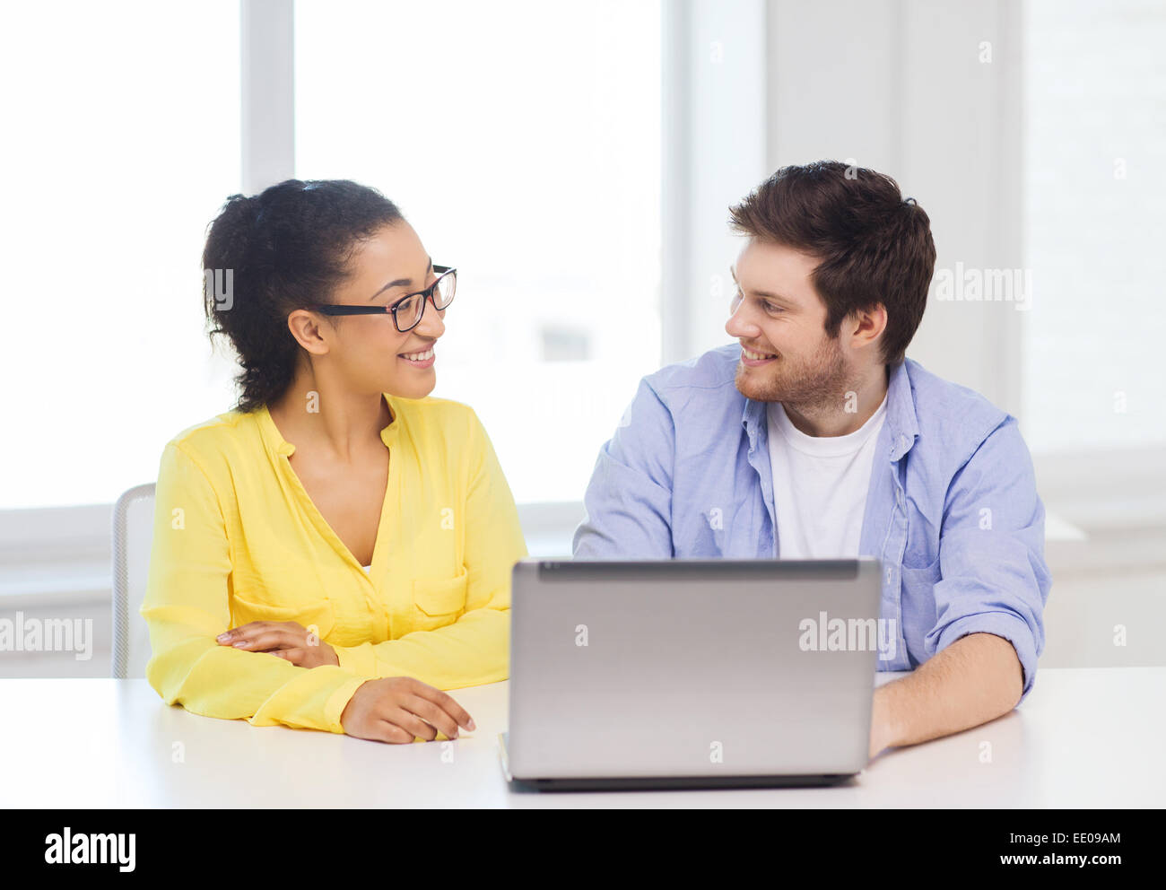 two smiling people with laptop in office Stock Photo - Alamy