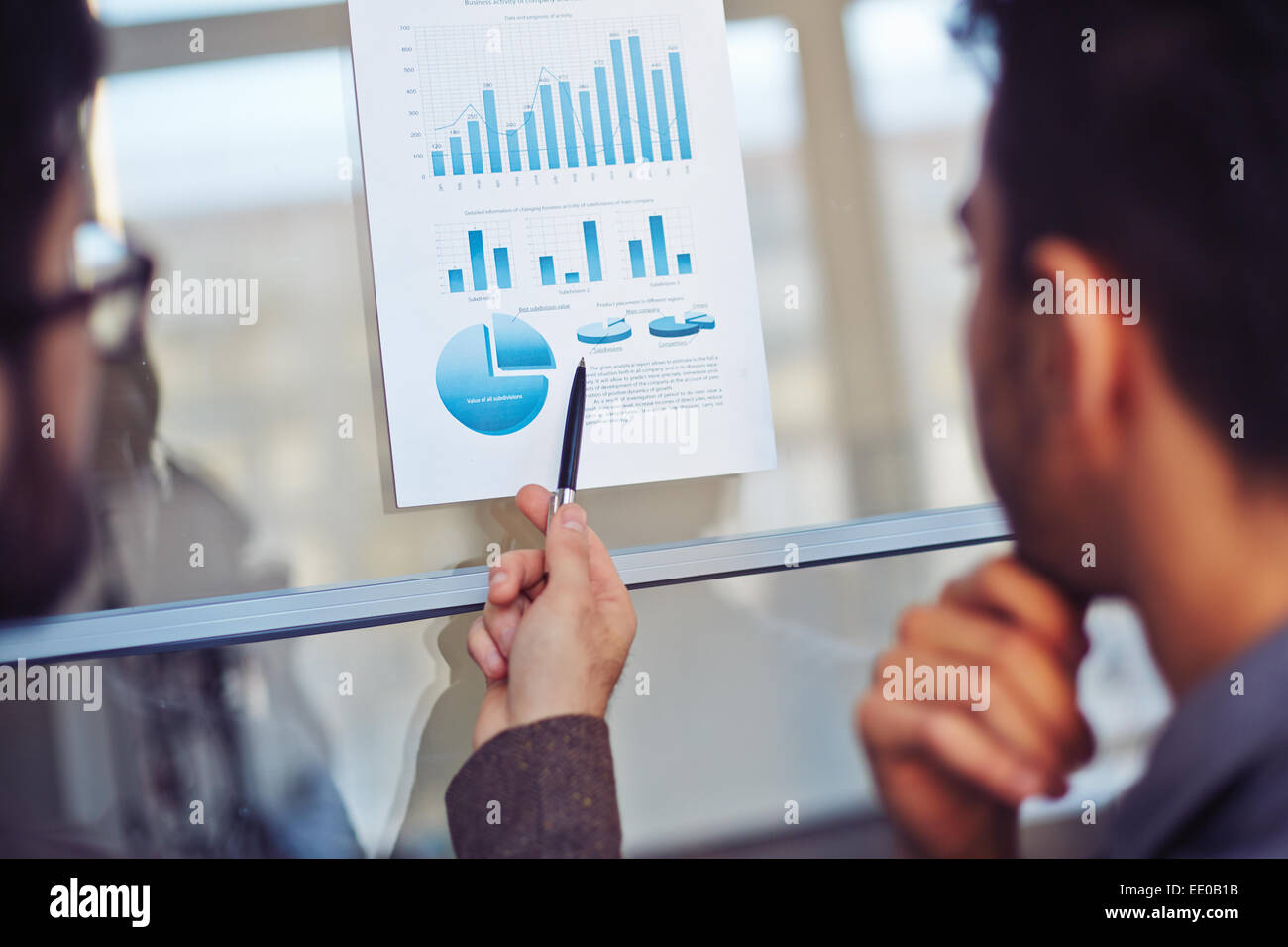 Businessman explaining document with charts and diagrams to his ...