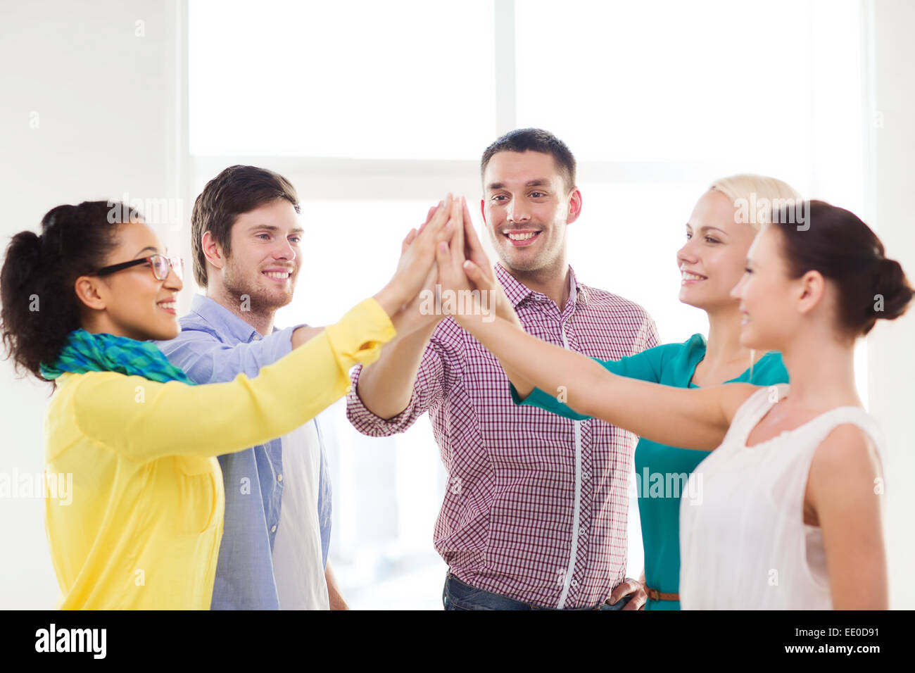 creative team doing high five gesture in office Stock Photo - Alamy