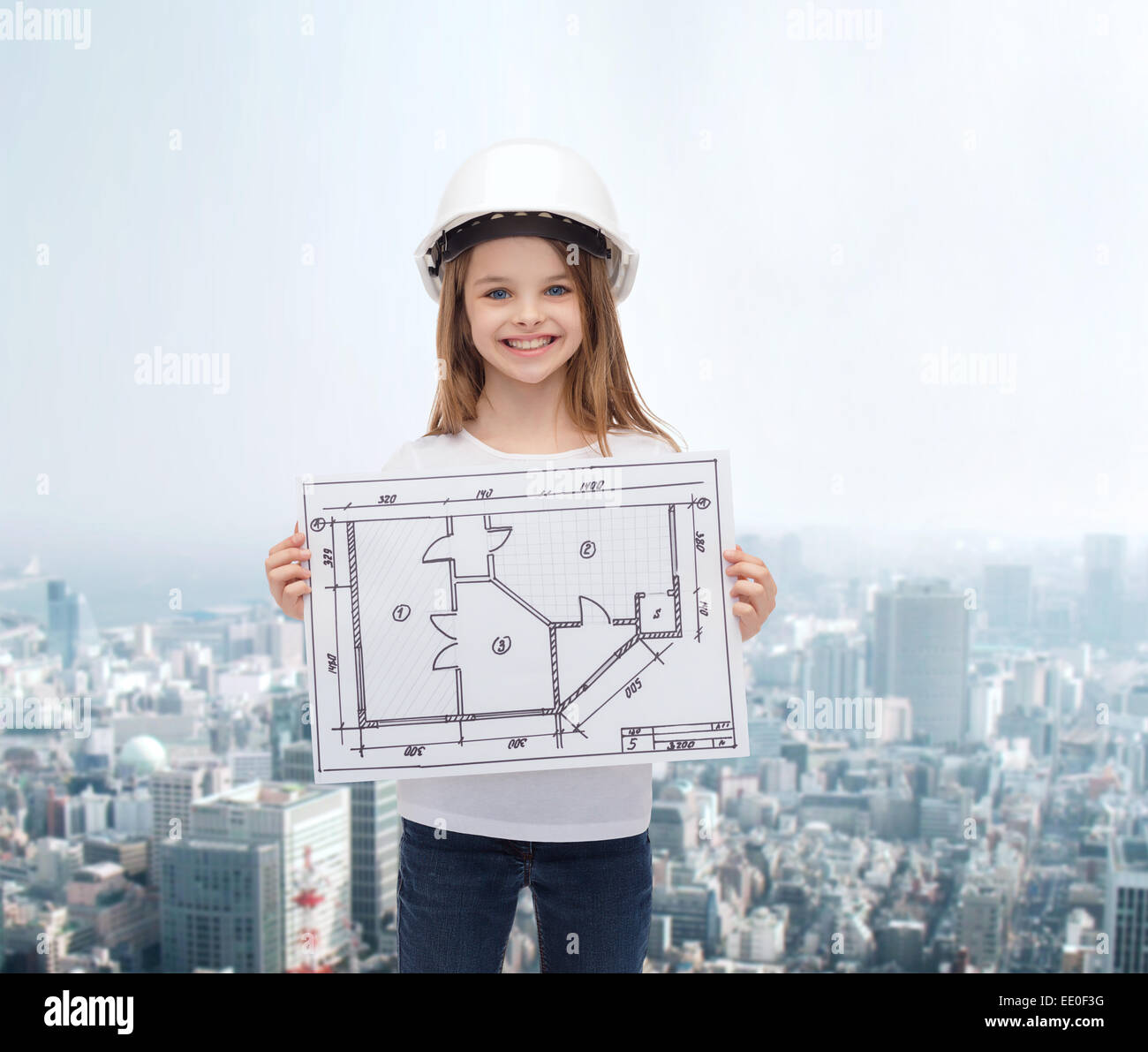 smiling little girl in helmet showing blueprint Stock Photo - Alamy