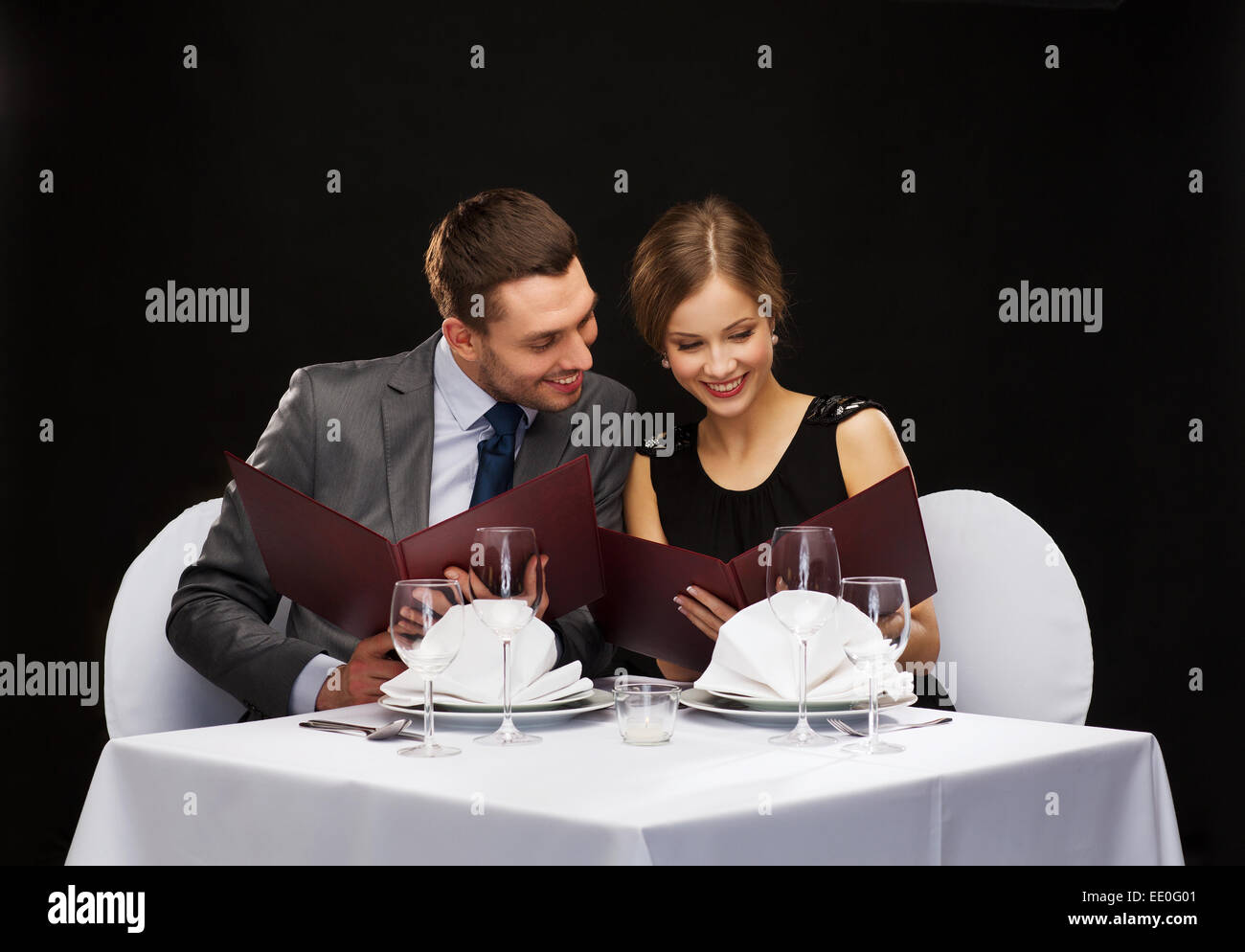 smiling couple with menus at restaurant Stock Photo - Alamy