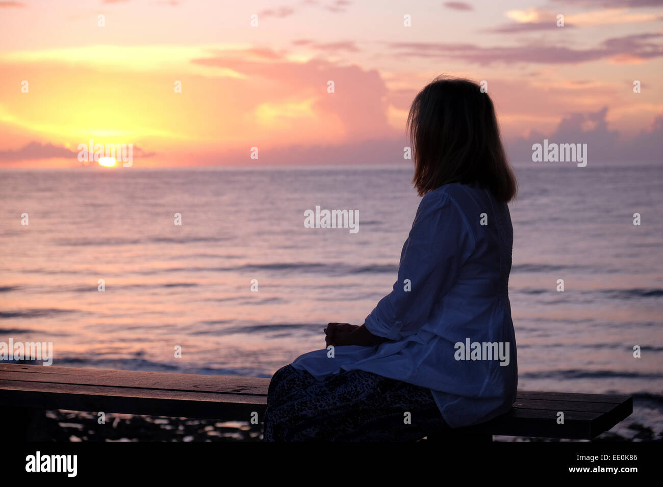 Woman looking at sun setting hi-res stock photography and images - Alamy