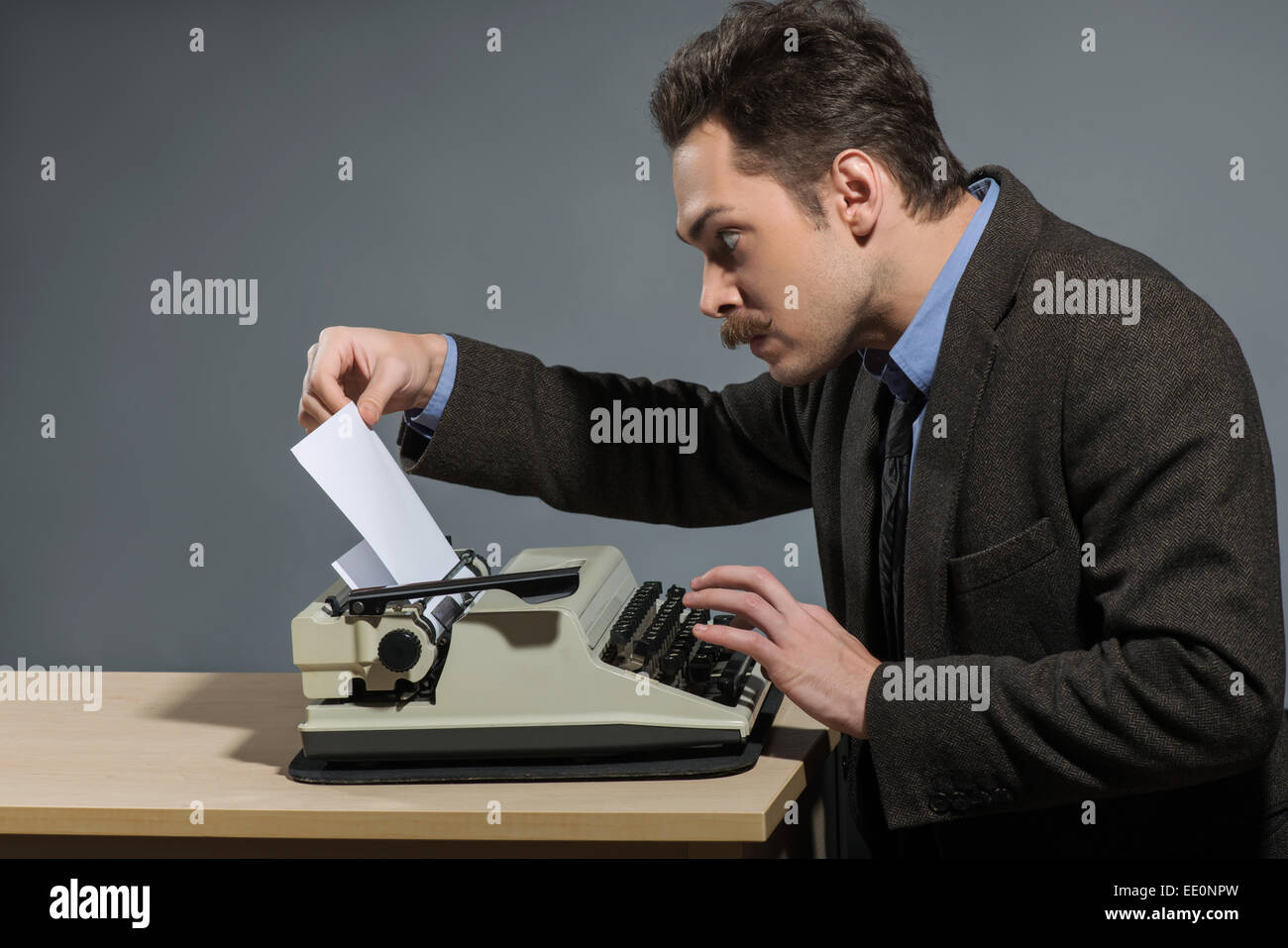 Happy young author typing at typewriter Stock Photo - Alamy