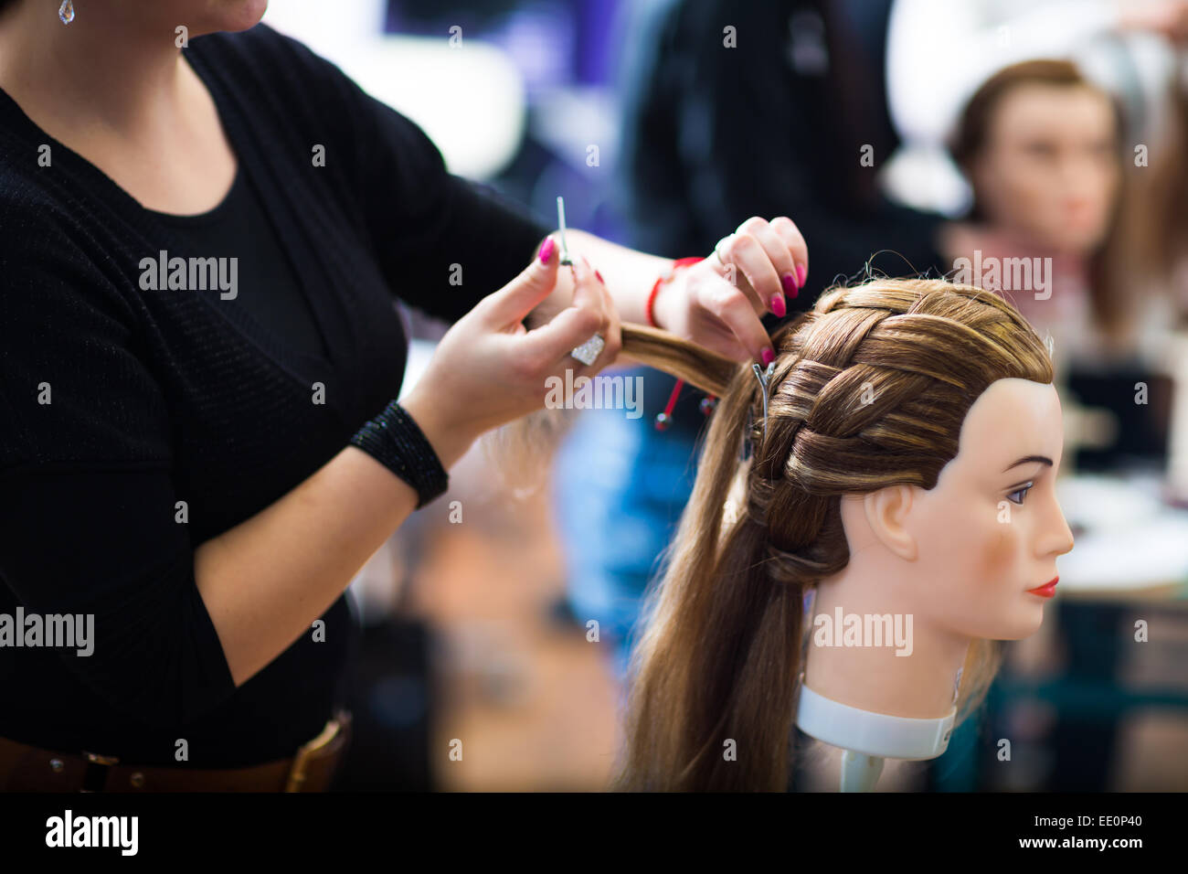 Pretty female hairdresser/haidressing apprentice/student training on an ...