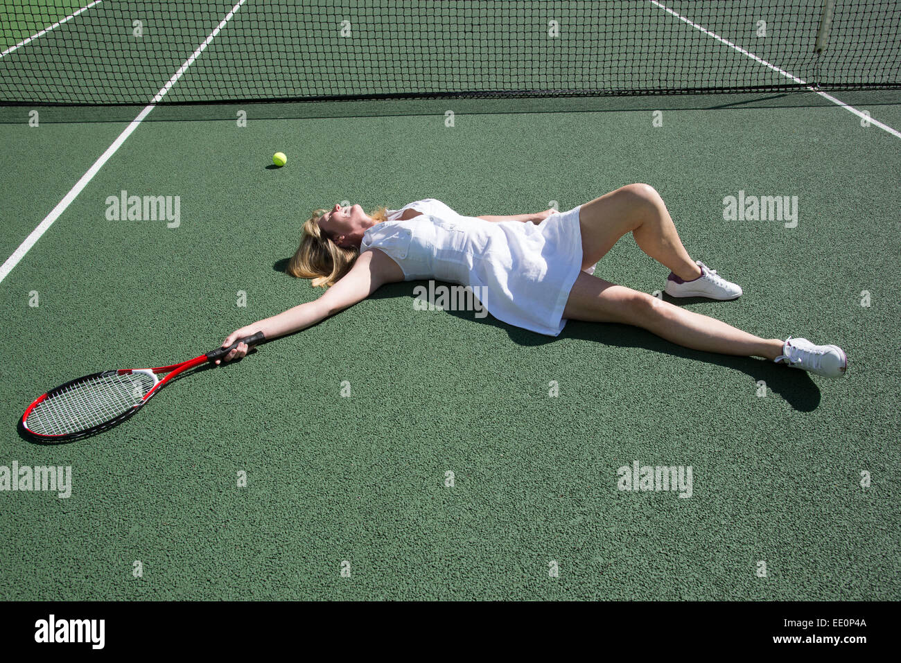 Tennis player on the ground after missing a shot on court Stock Photo ...