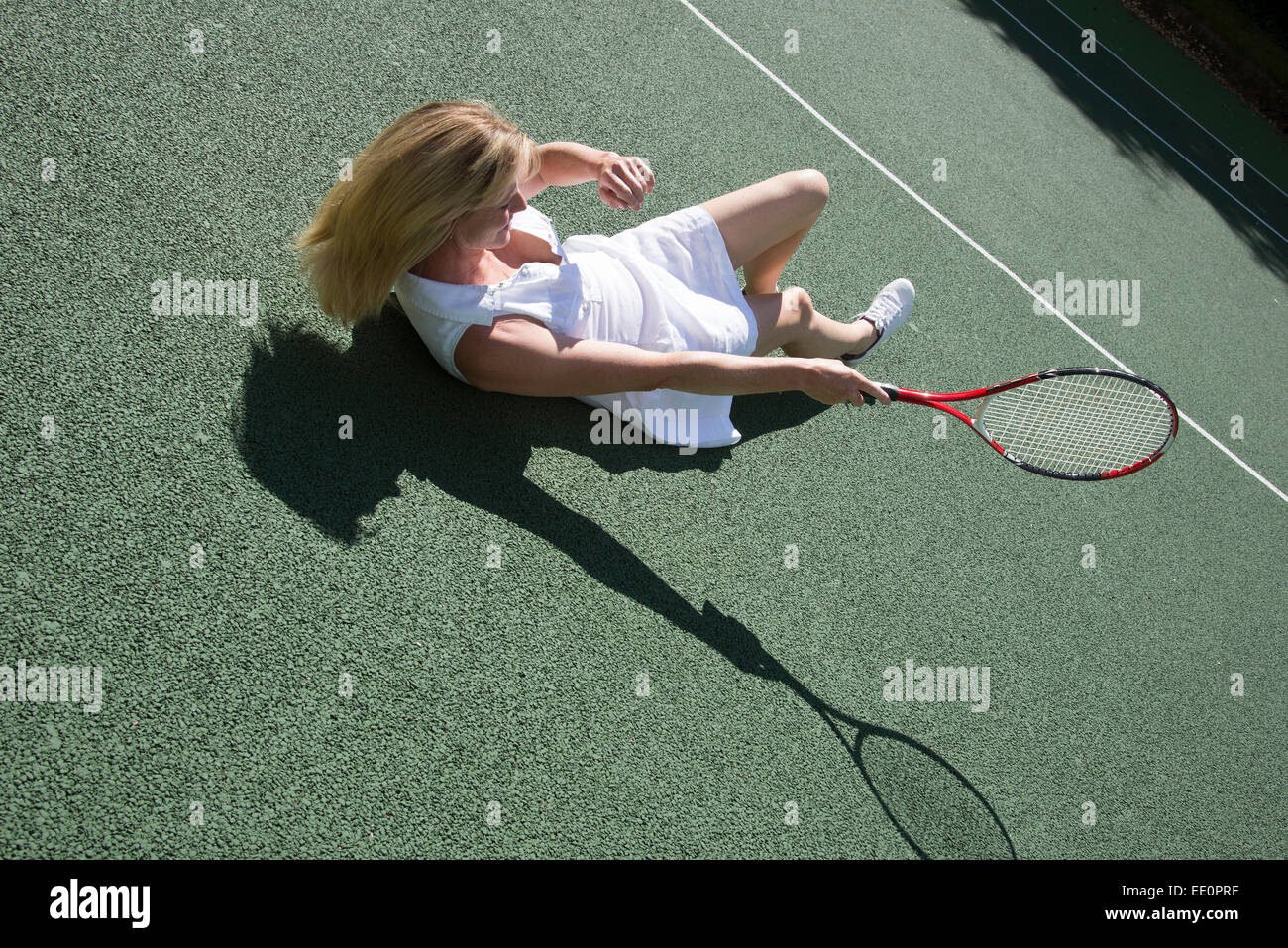 Tennis player on the ground after missing a shot on court Stock Photo ...