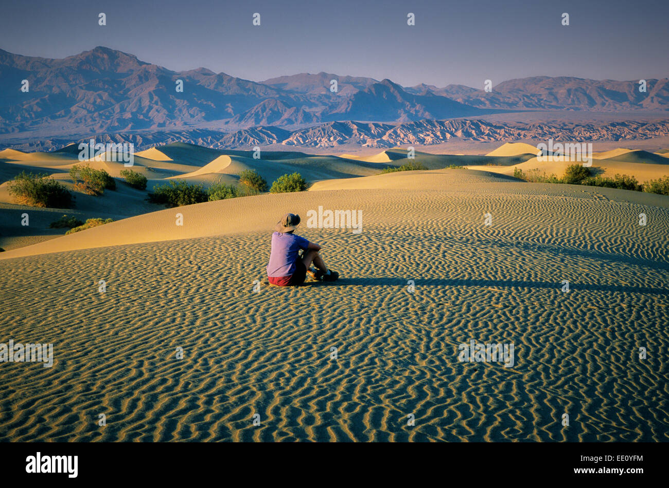 Woman enjoying a moment of solitude sitting in a desert Stock Photo - Alamy