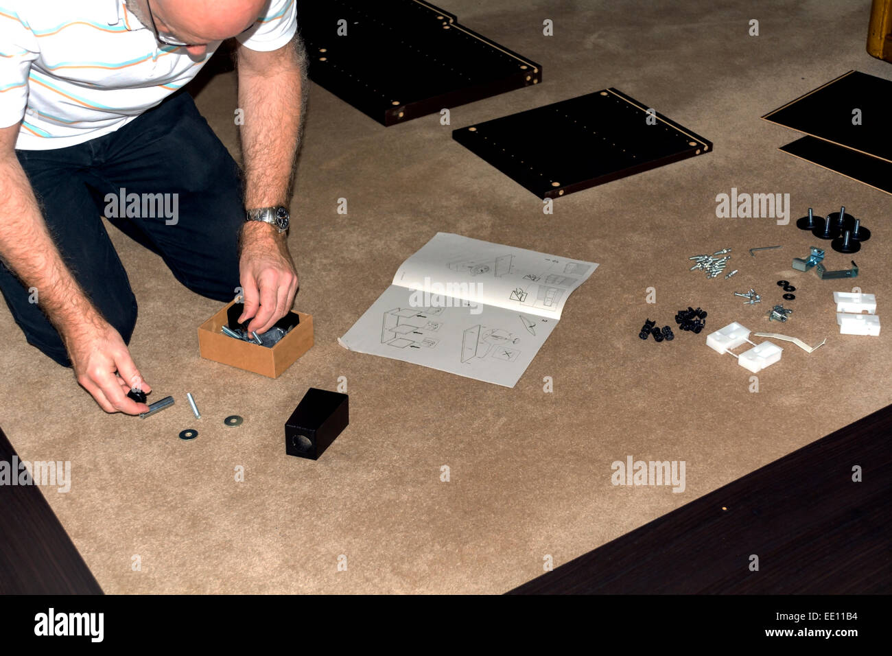 This man is assembling flat-packed furniture Stock Photo - Alamy