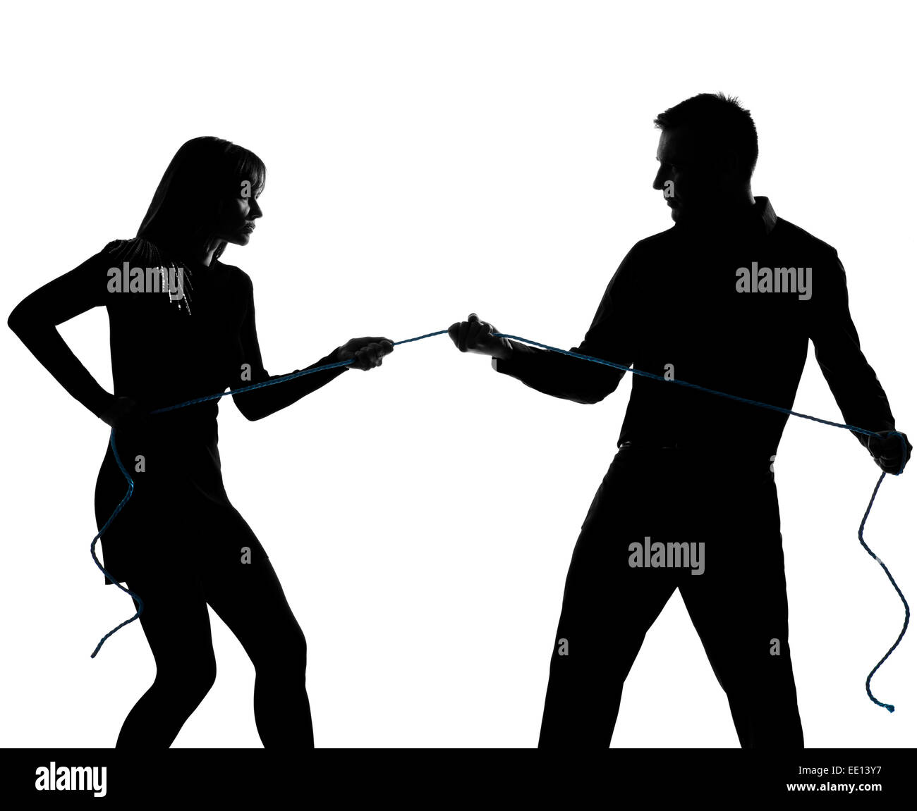 one caucasian couple man and woman pulling a rope in studio silhouette ...