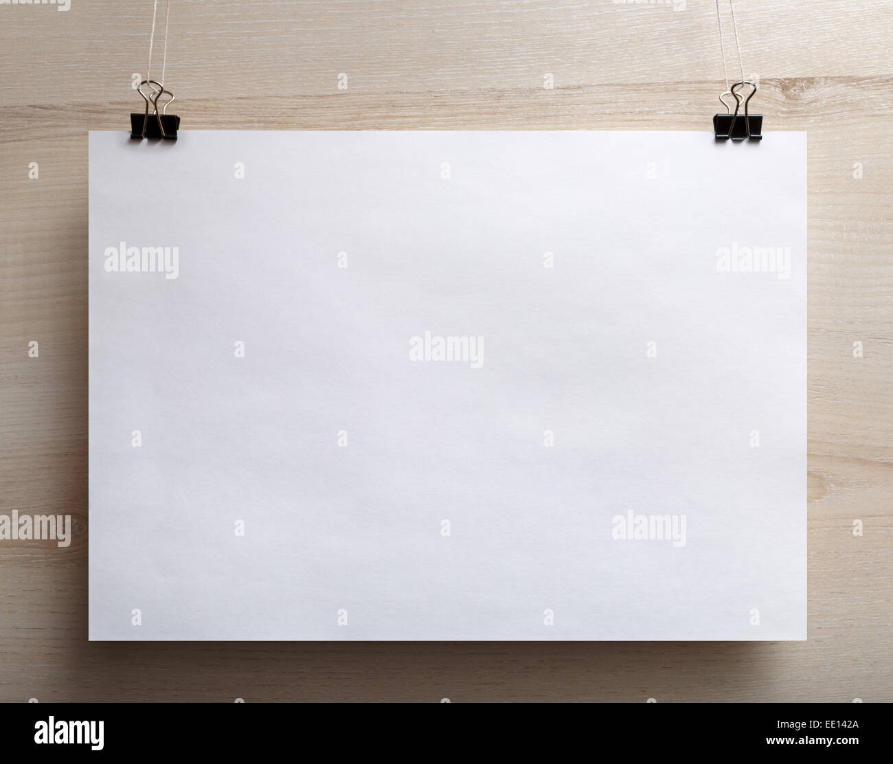 White paper poster hanging on light wooden background Stock Photo - Alamy