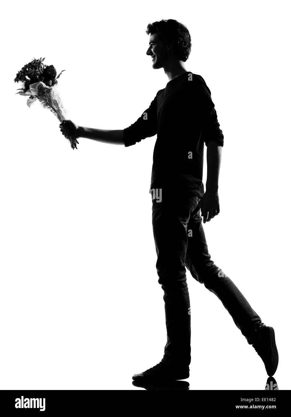 young man offering flowers bouquet silhouette in studio isolated on ...