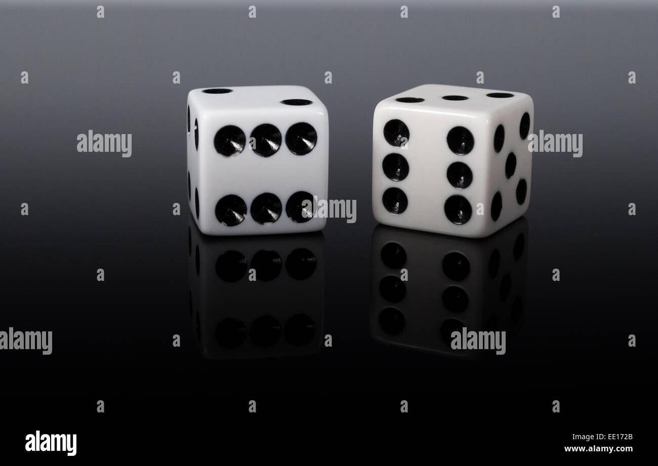 Two white dice on black reflect background Stock Photo - Alamy