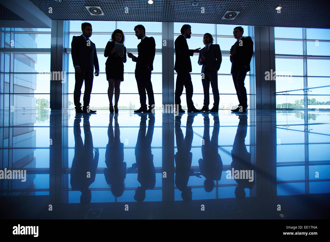 Group of business people communicating in the hall Stock Photo - Alamy