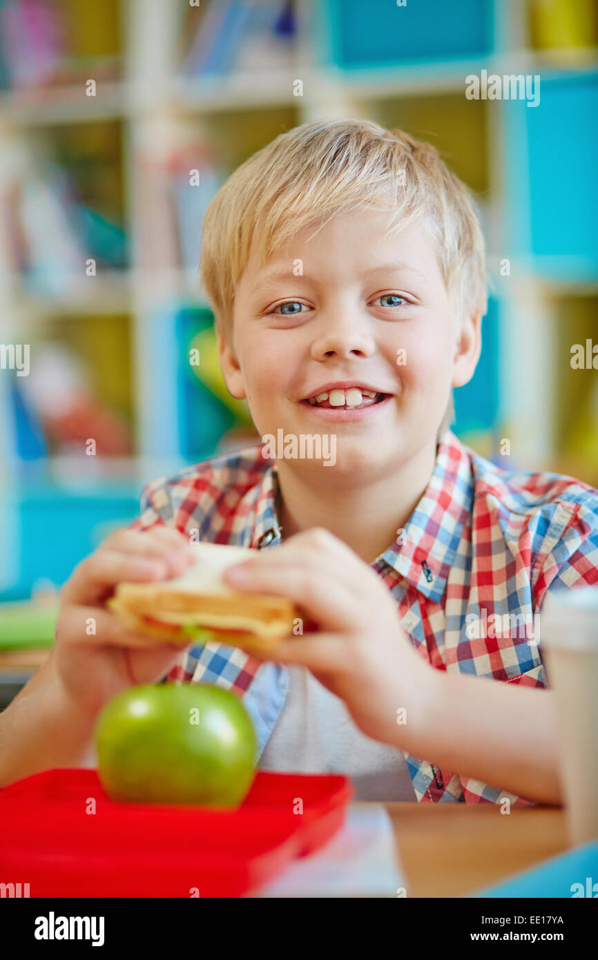 Happy schoolboy with sandwich having snack at break Stock Photo - Alamy